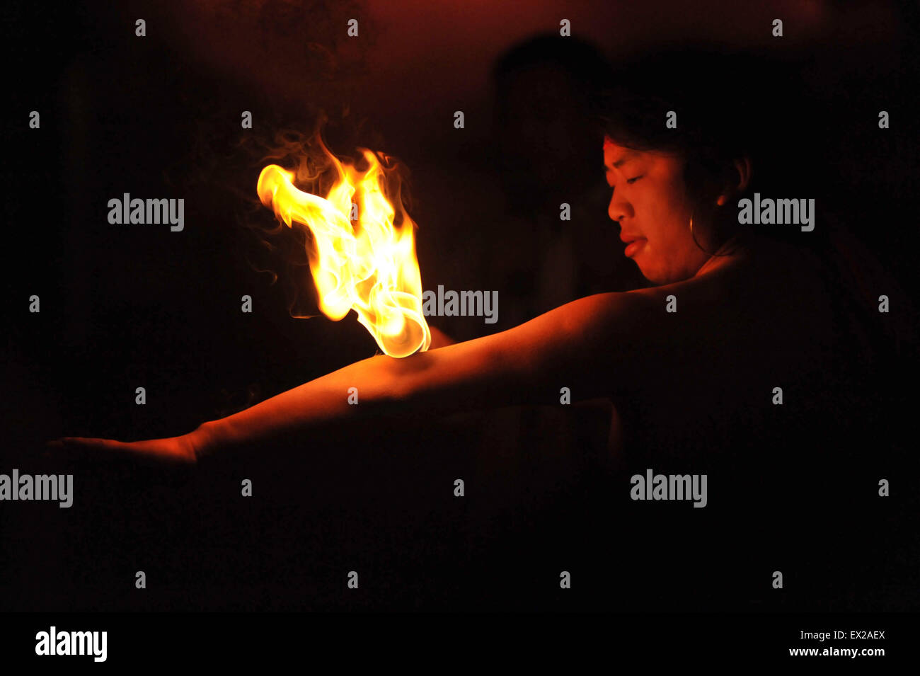 A performer places a torch into his mouth during a stunt performance ...