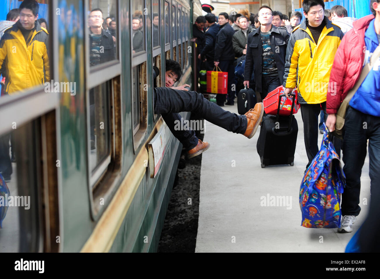 A passenger jumps out from a window of a carriage of a train at a ...