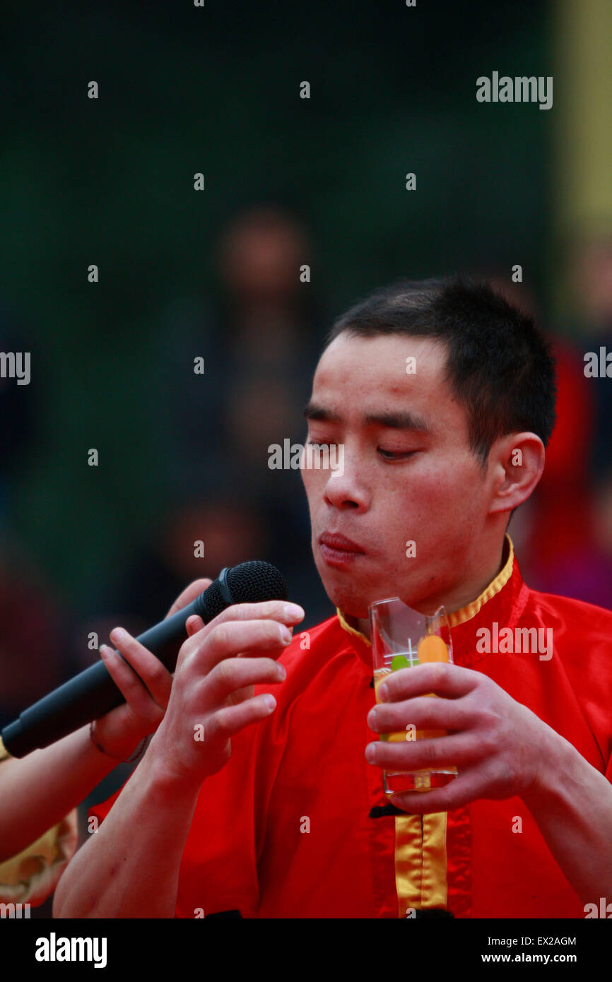 A stunt performer performs eating glass cup for visitors to welcome the ...