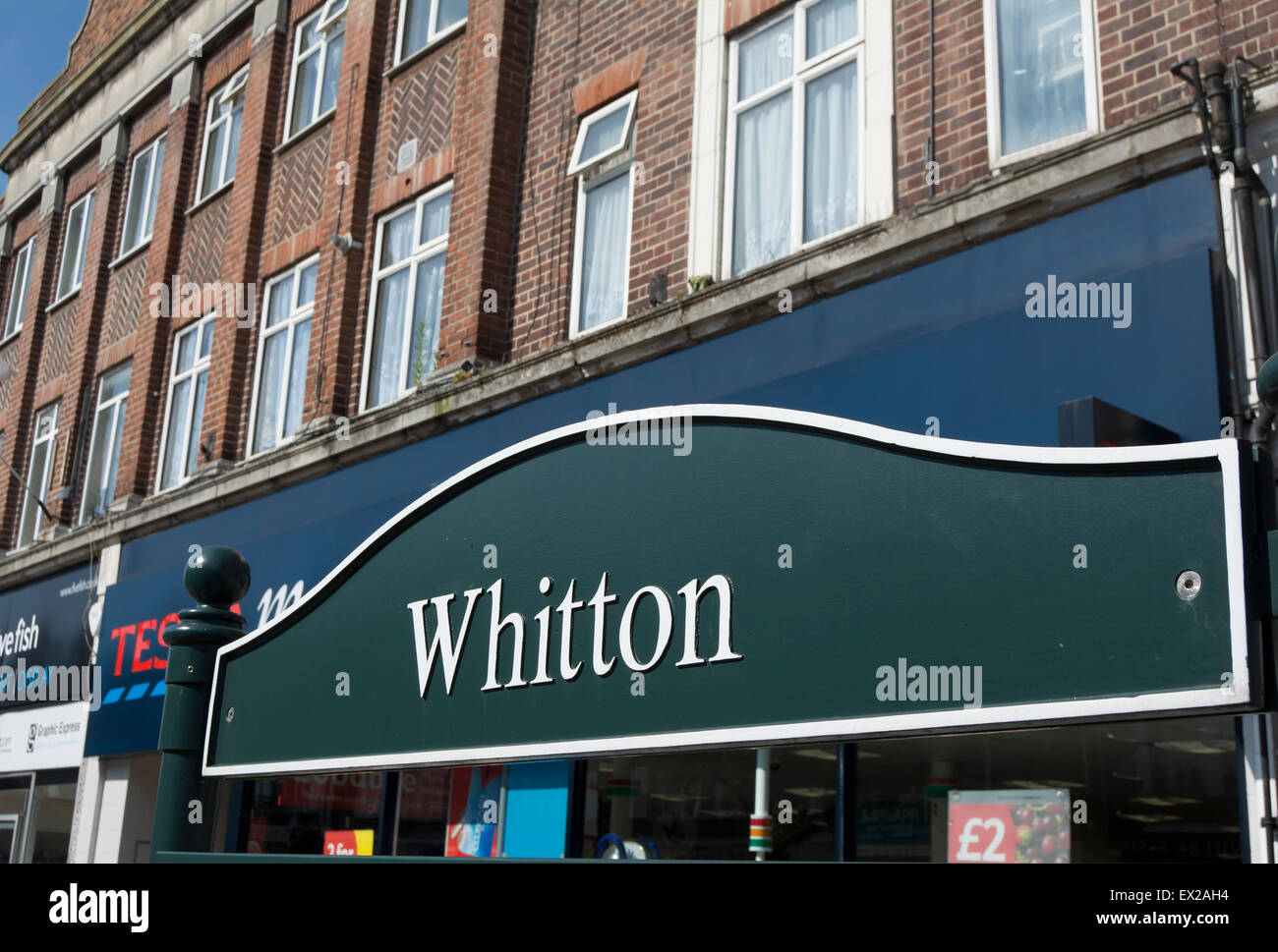 street sign for whitton, in middlesex, england, with high street shops ...