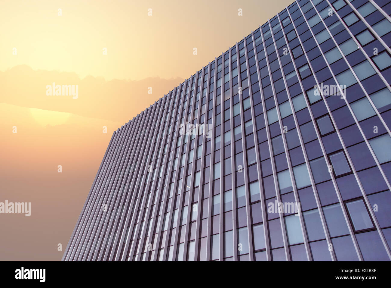 Close up bottom view of a modern glass-lined plaza building, on sunrise ...