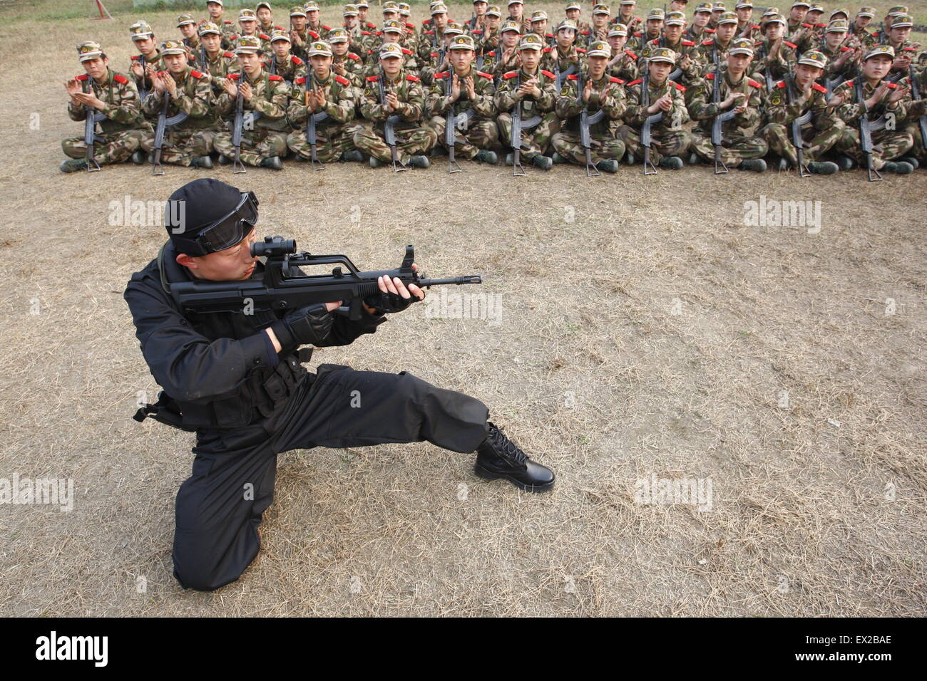 A paramilitary policeman demonstrates shooting while stepping over ...