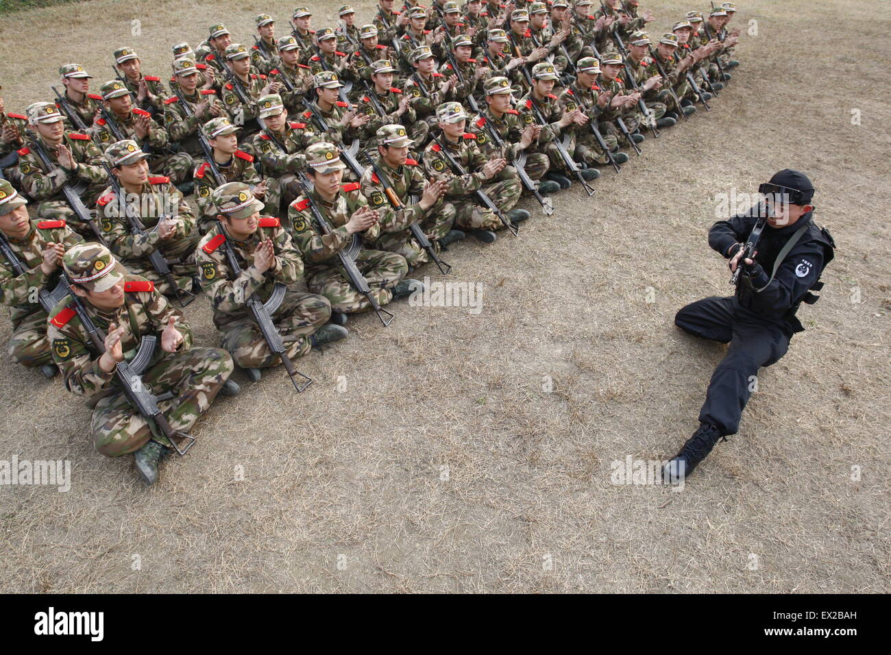 A paramilitary policeman demonstrates shooting while stepping over ...