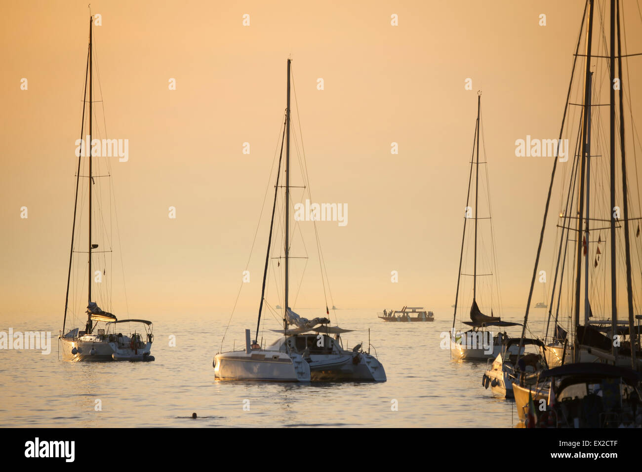 Sunset over anchored sailboats in hi-res stock photography and images ...