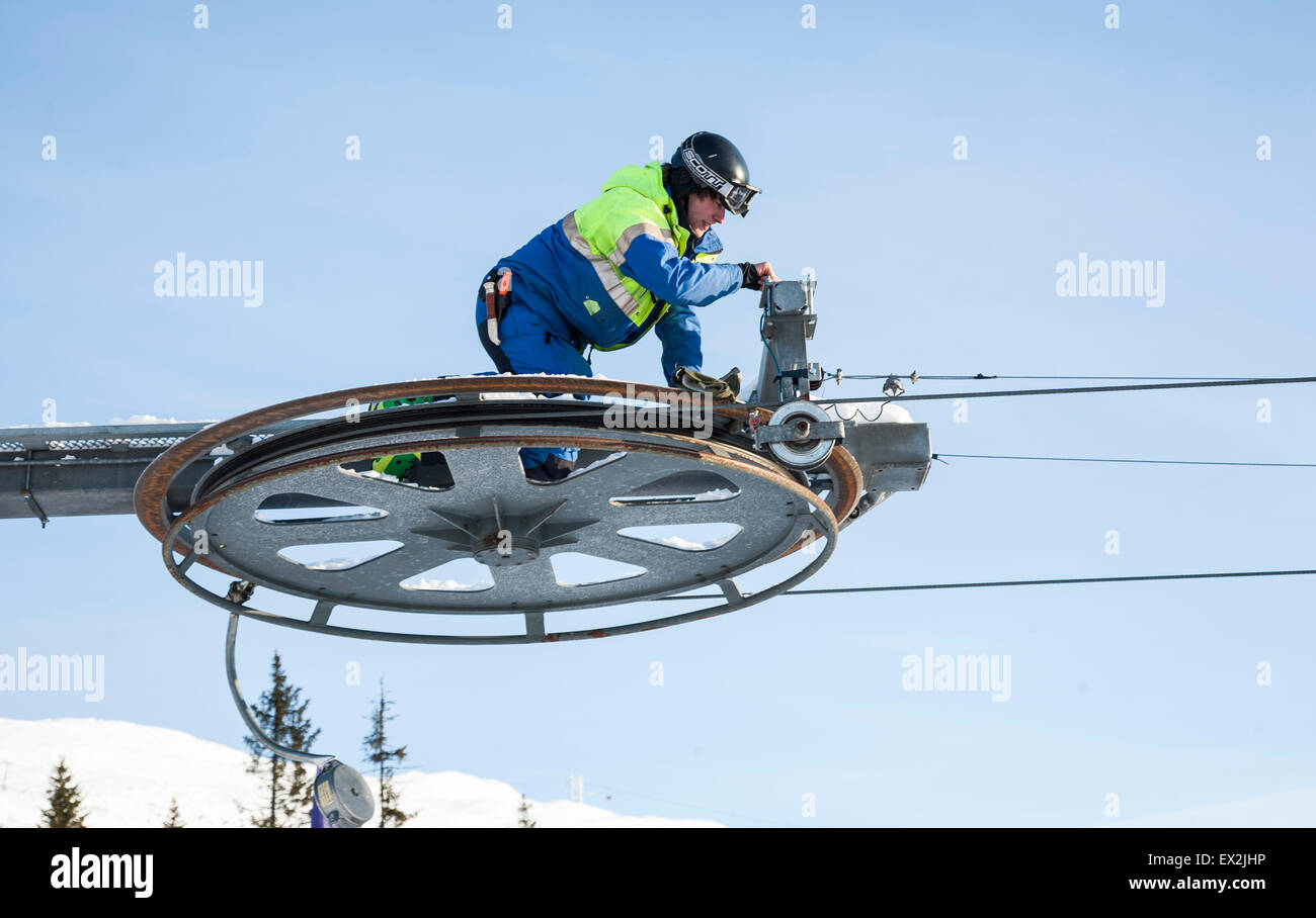A man repairing the wheel on a ski lift Stock Photo - Alamy