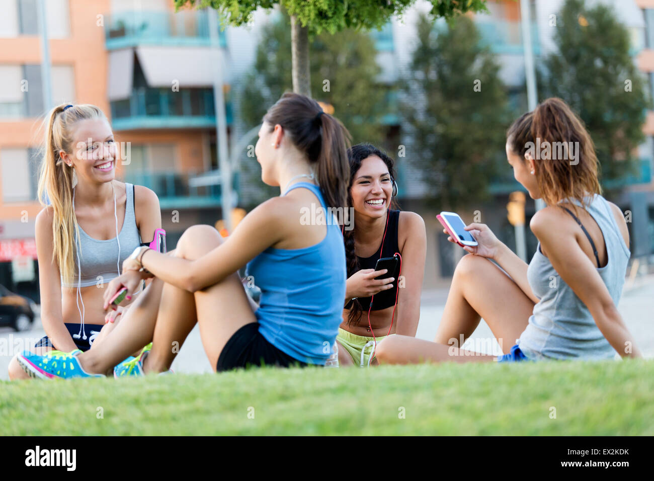 Outdoor portrait of running girls having fun in the park with mobile ...