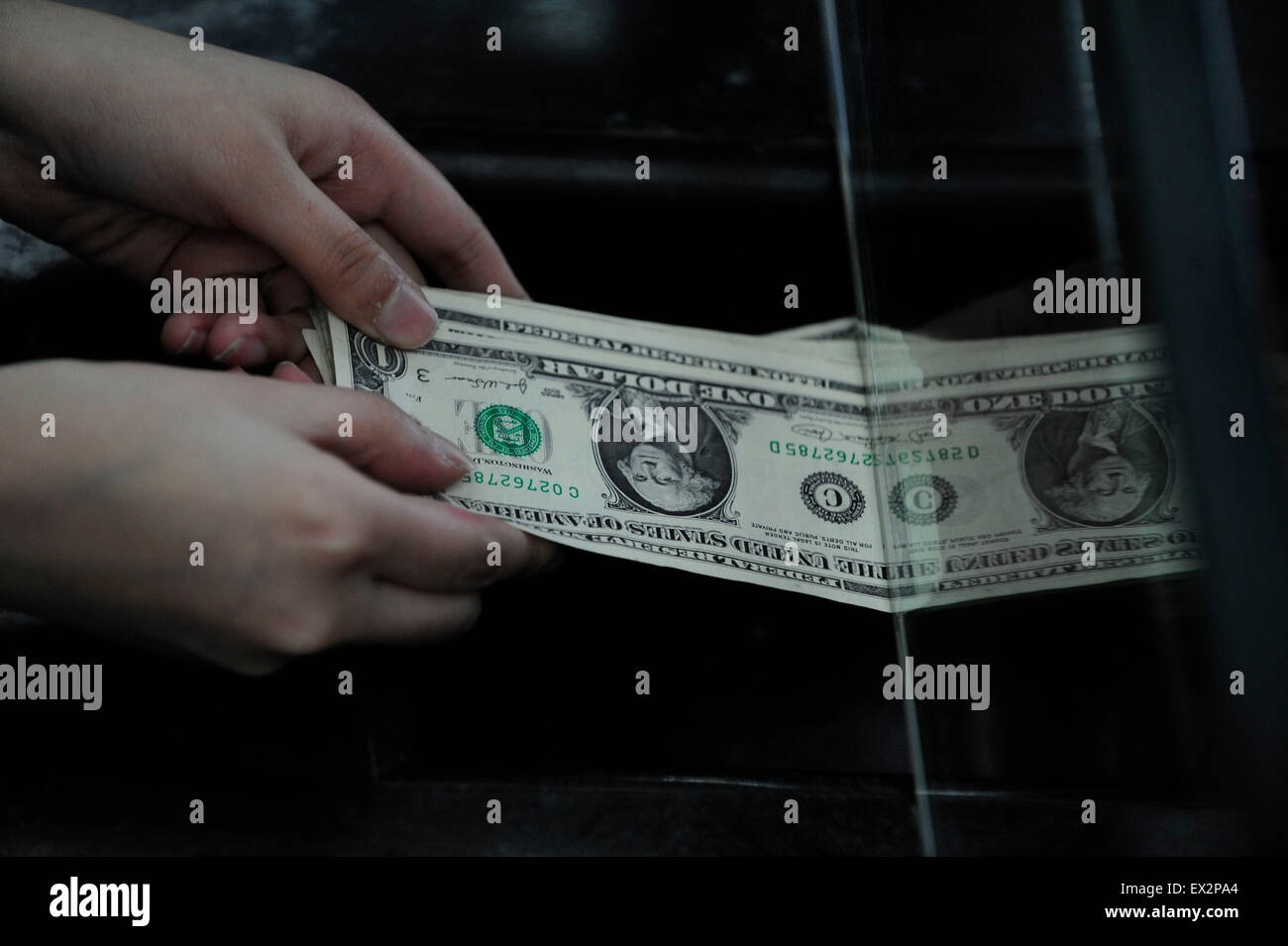 An employee hands over U.S. dollar banknotes to a customer at a branch ...