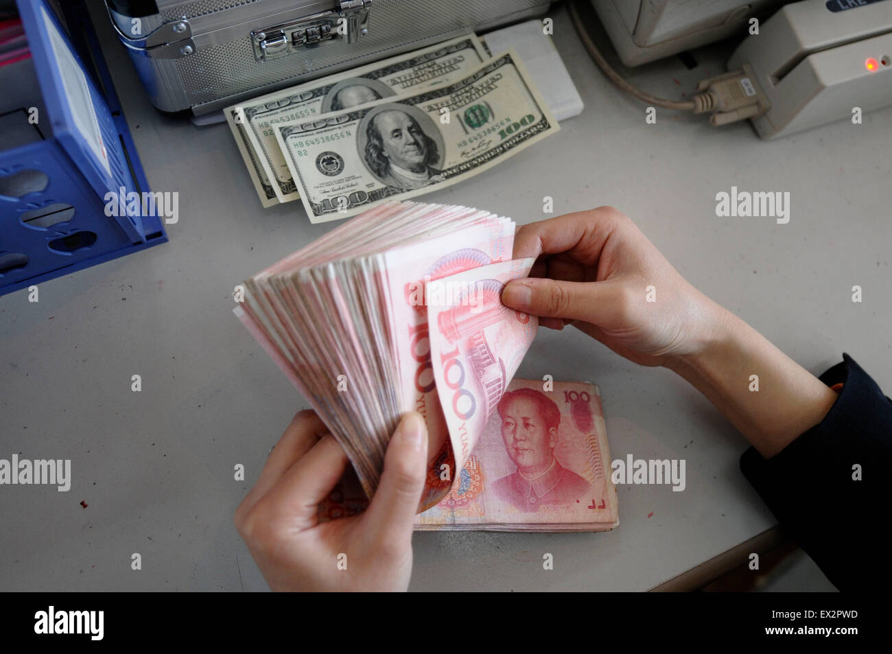An employee counts Chinese yuan banknotes at a branch of Bank of China ...
