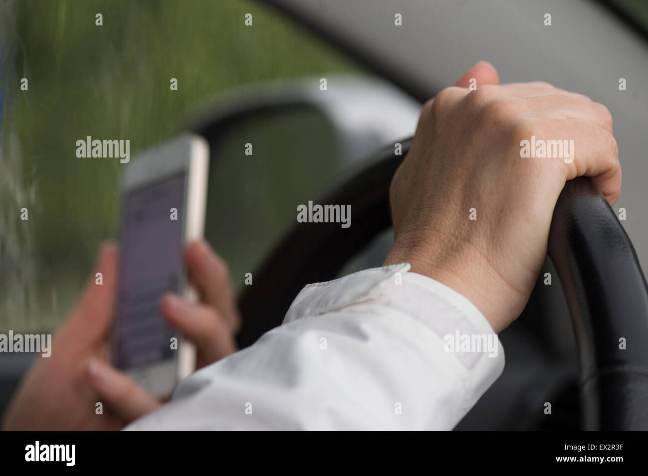 Reading text message while driving a car Stock Photo - Alamy