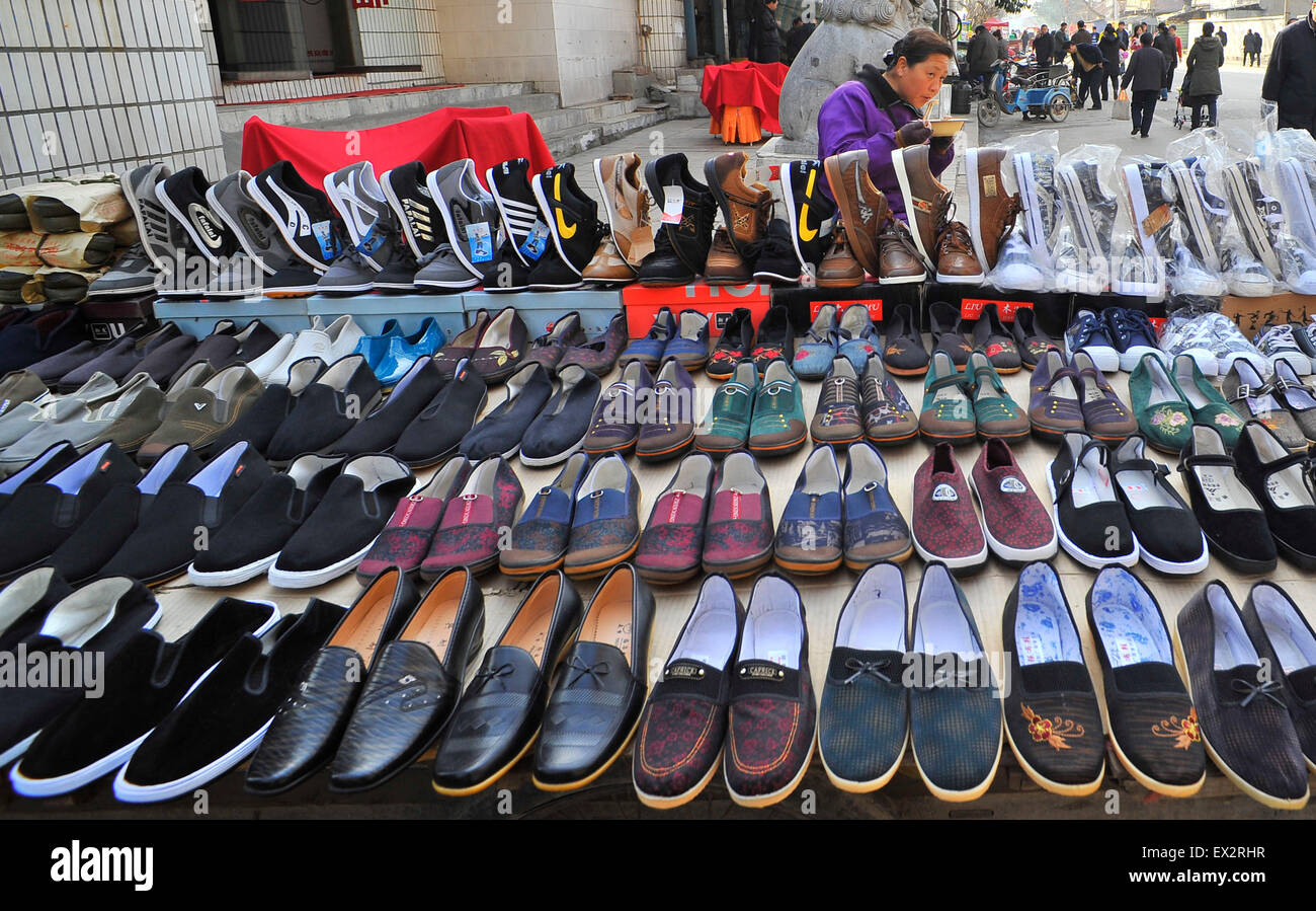 A shoe vendor sells on a street in Xiangfan, Hubei province March 16 ...