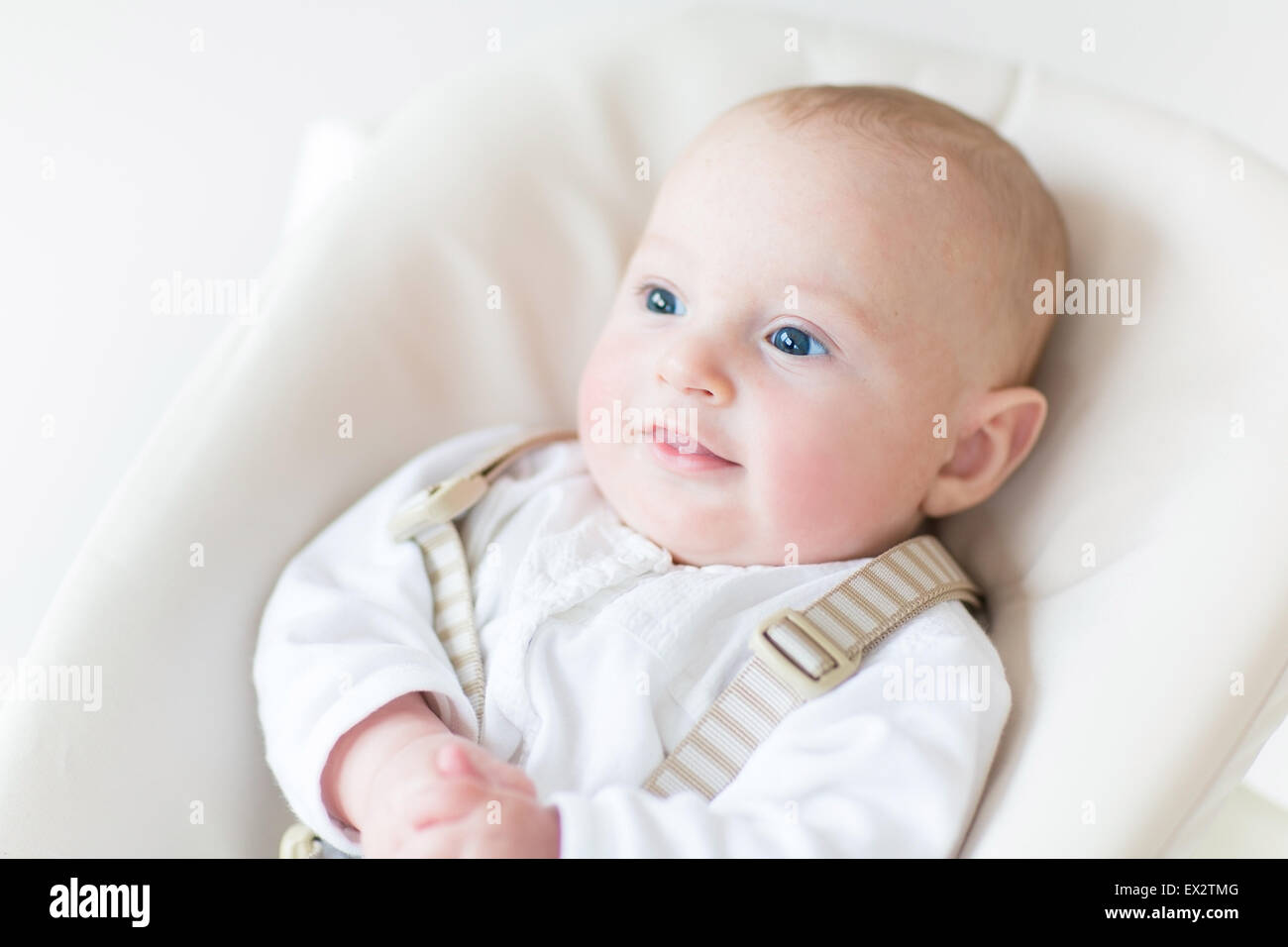 Happy smiling baby boy in a white chair Stock Photo - Alamy