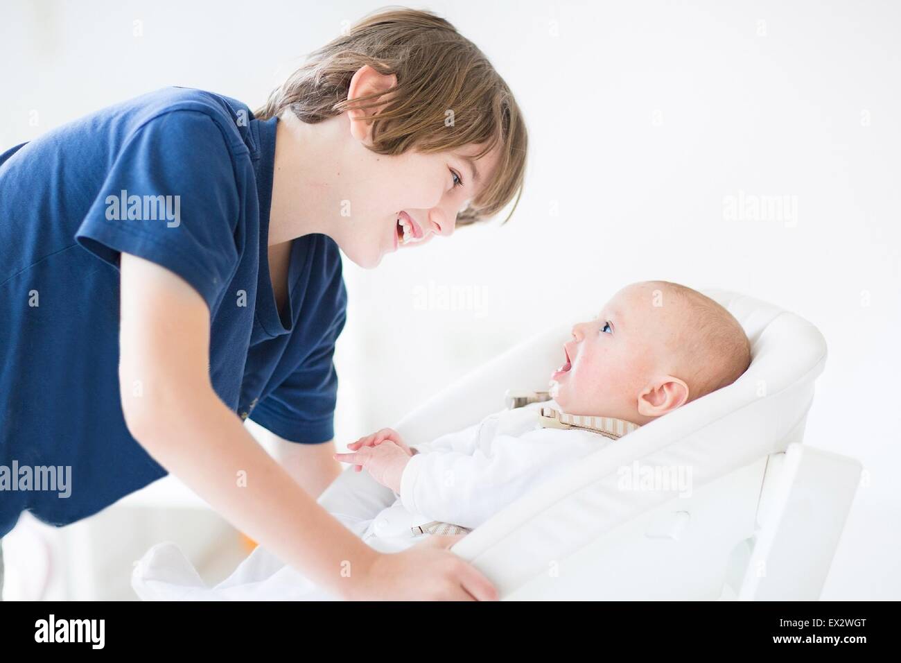 Happy laughing boy talking to his newborn baby brother Stock Photo - Alamy