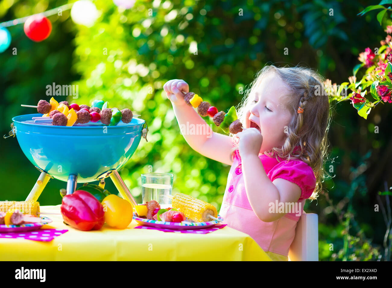Children grilling meat. Family camping and enjoying BBQ. Little girl at ...