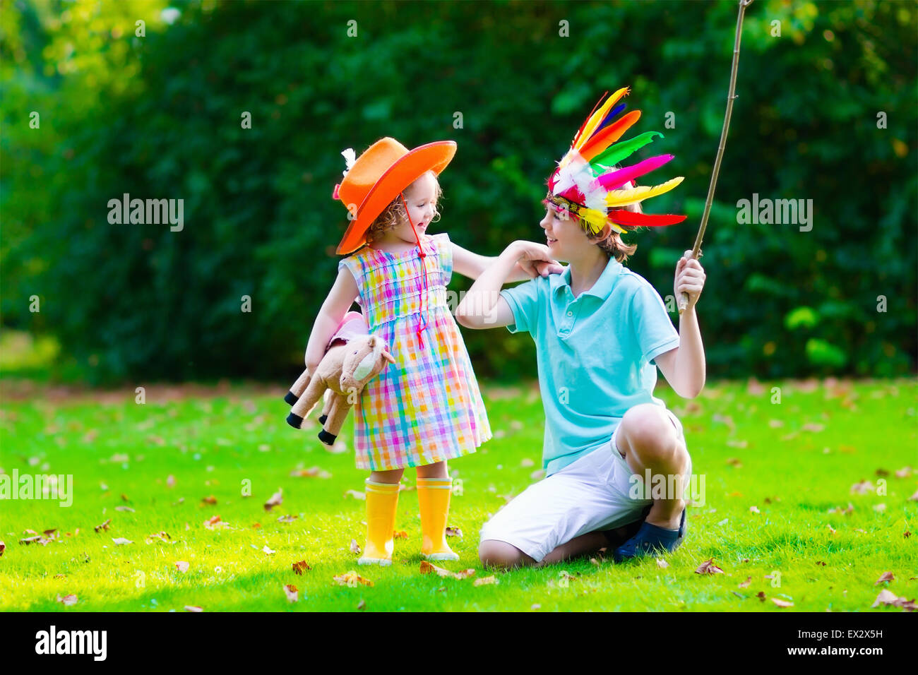 Kids in cowboy and cowgirl costumes playing outdoors. Children play ...