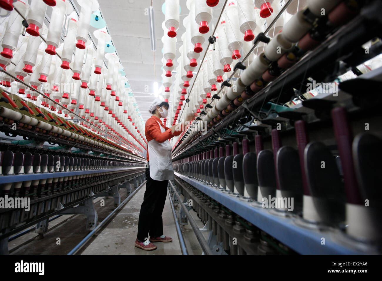A female labourer works at a textile factory in Huaibei, Anhui province ...