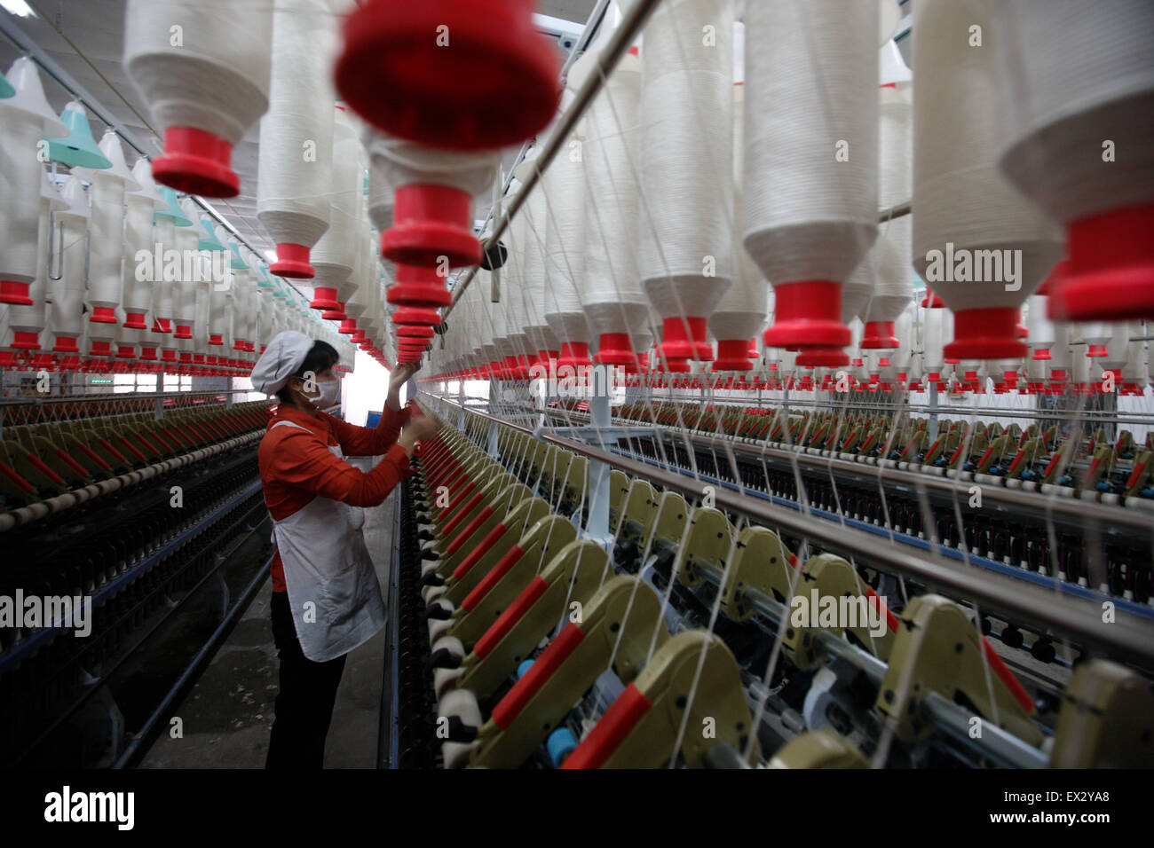 A female labourer works at a textile factory in Huaibei, Anhui province ...
