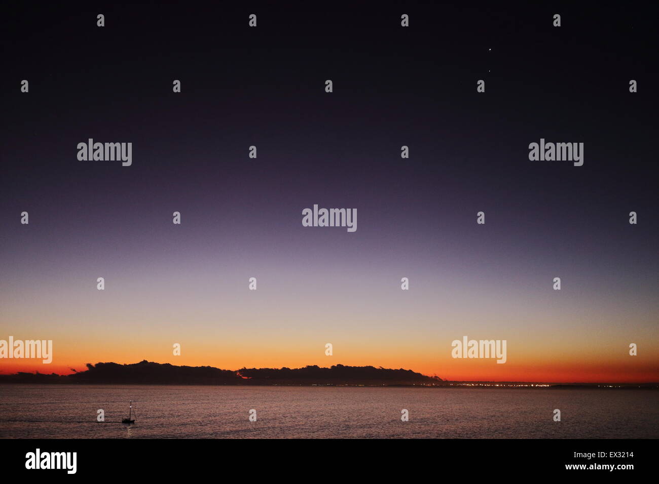 Sunset over False Bay and the Cape Peninsula with a yacht in the bay ...