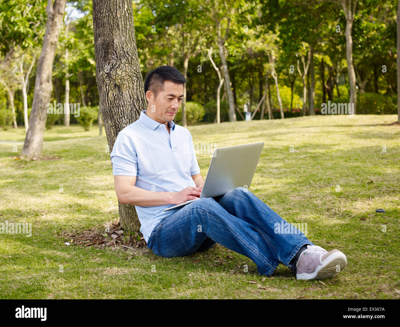 asian man in using laptop outdoors Stock Photo - Alamy