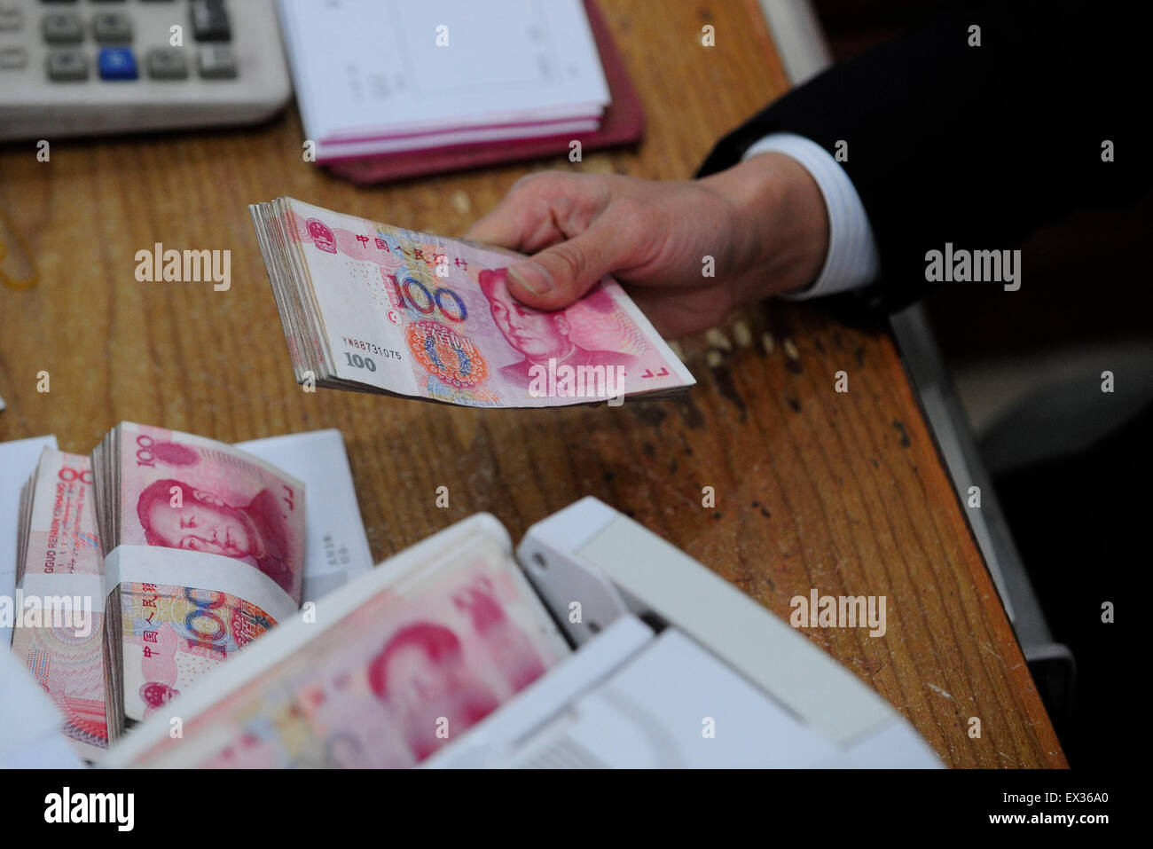 An employee counts Yuan banknotes at a branch of Bank Of China in Hefei ...