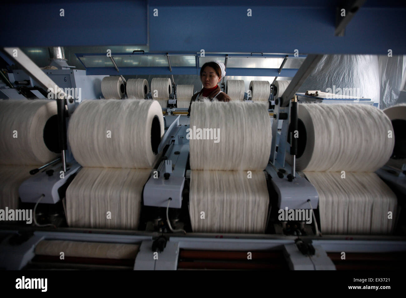 A female labourer works at a textile factory in Huaibei, Anhui province ...