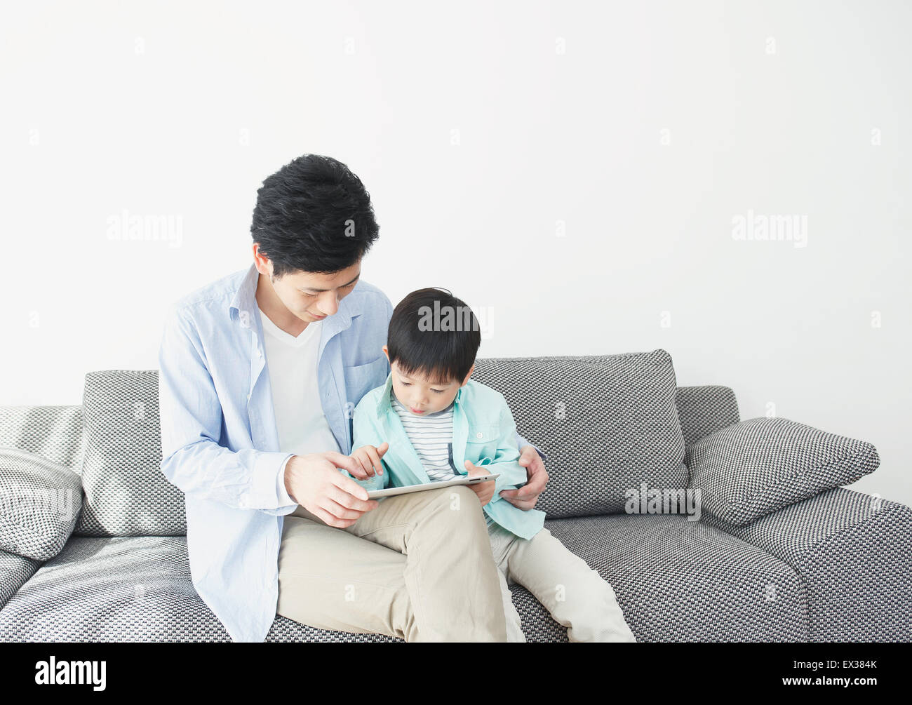 Japanese father and son on the sofa with tablet Stock Photo - Alamy