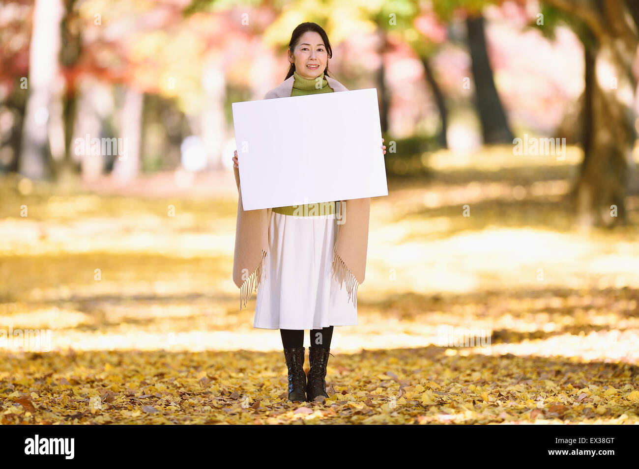 Senior Japanese woman with whiteboard in a city park in Autumn Stock ...