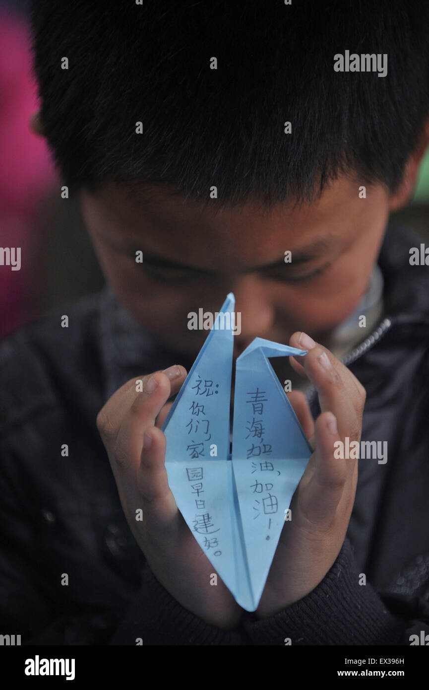 Pupils of a primary school stand still with a paper-crane to mourn the ...