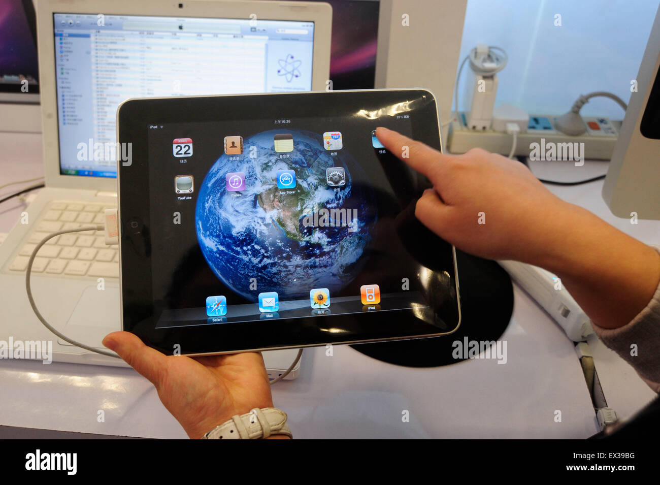 A shop assistant displays an iPad at an electronic products store in ...