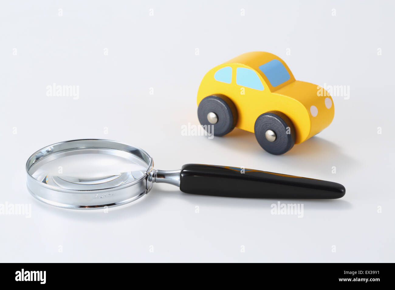 Wooden toy car and magnifying glass Stock Photo - Alamy