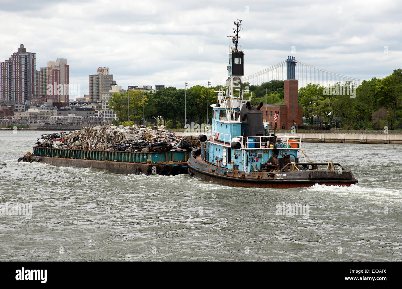 Tug and barge full of scrap metal for recycling on the East River ...