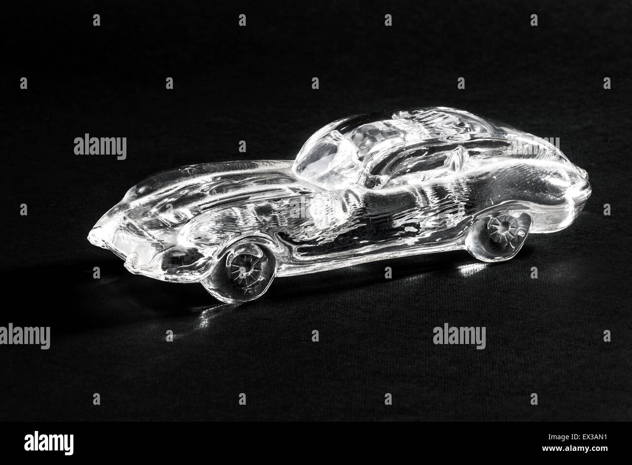 Ornamental glass model of retro classic car over a black background ...