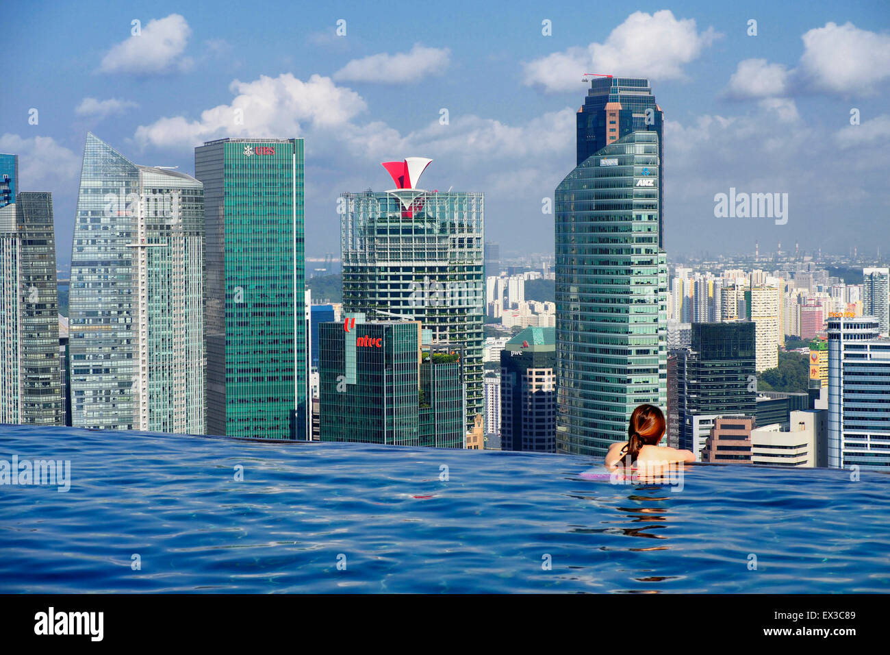 Woman at the MBS Infinity pool and enjoying the Singapore skyline Stock ...