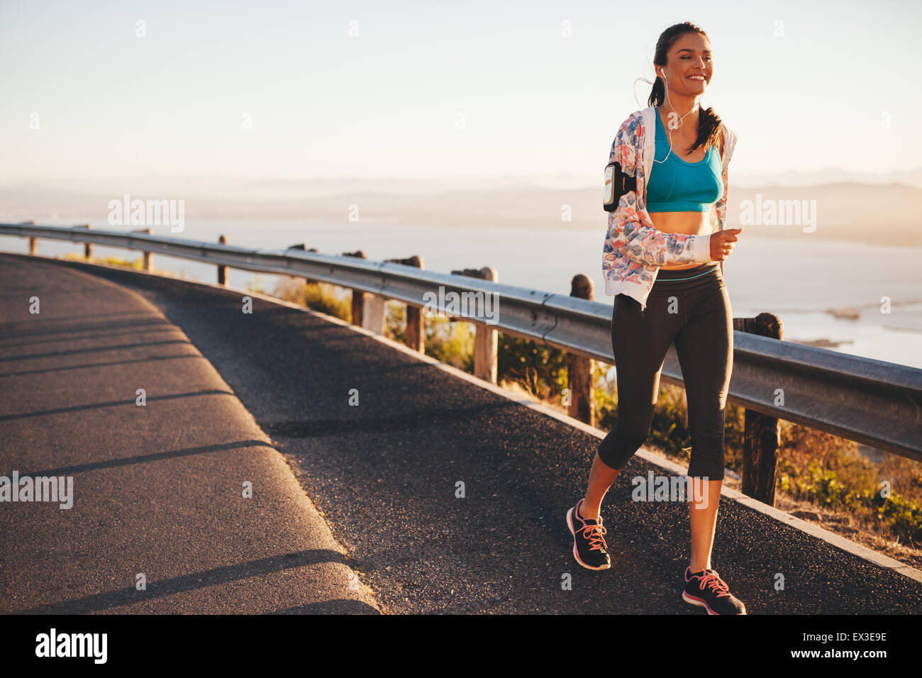 Portrait of happy young woman running on country road. Caucasian female ...