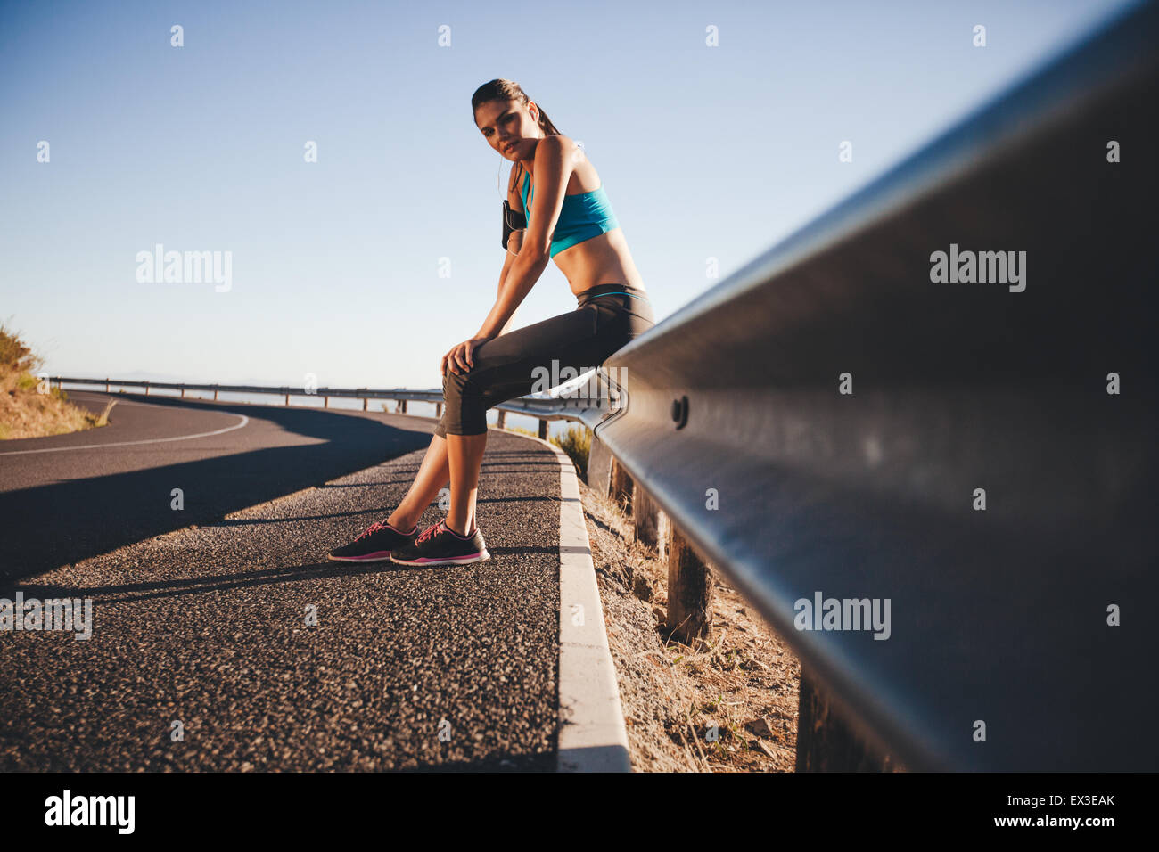 Tired young woman relaxing after a outdoor training session. Runner ...