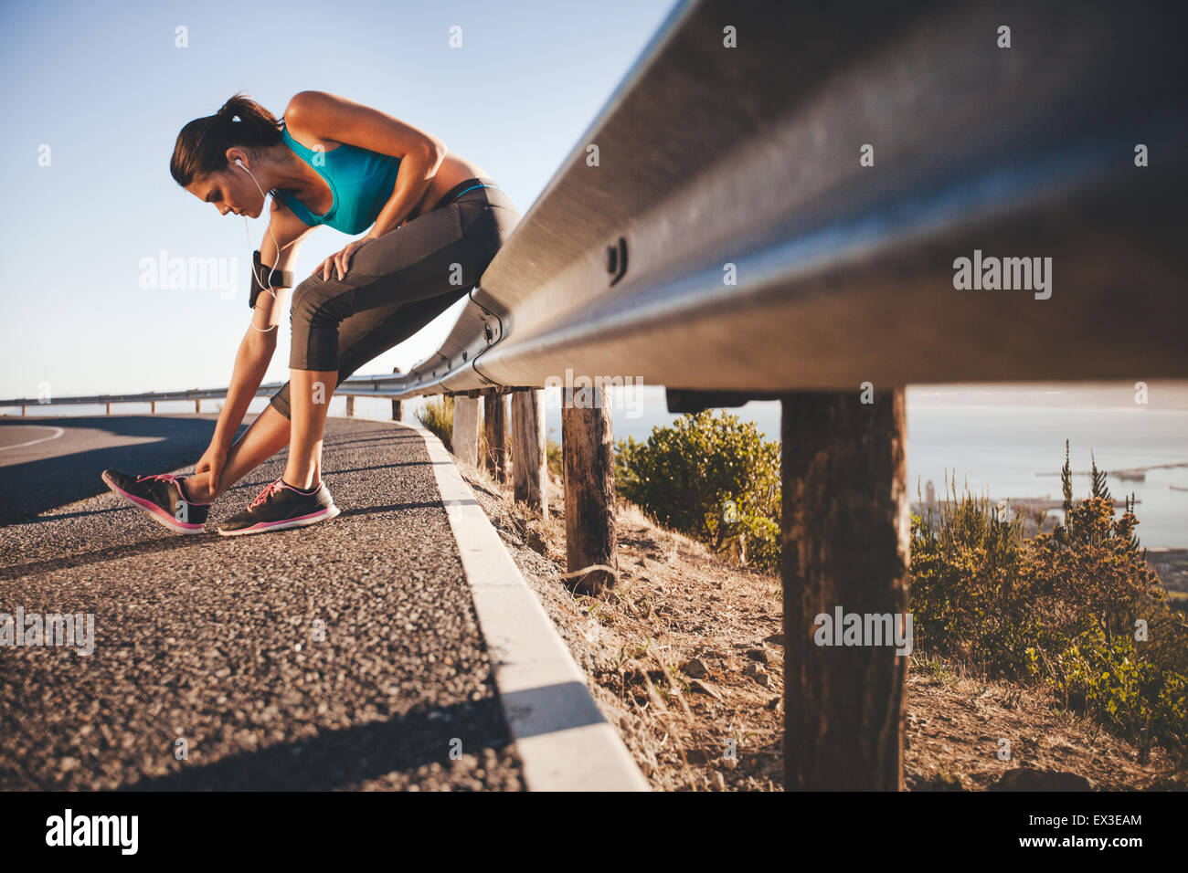 Sports woman stretching her leg after running outdoors. Female athlete ...
