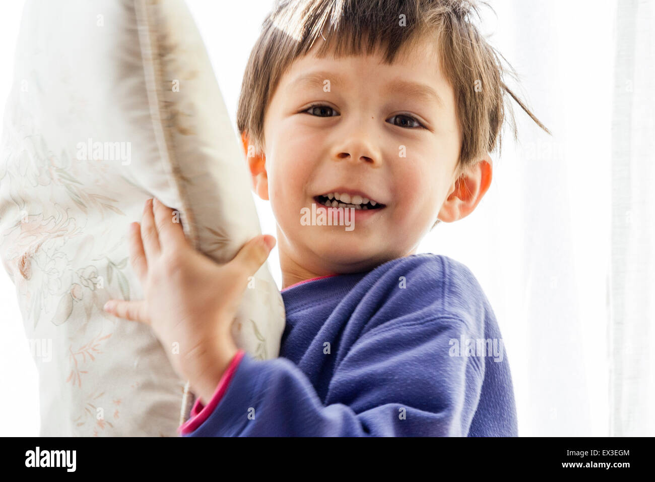 Smiling caucasian child, boy, 6-7 year old, using both hands to throw a ...