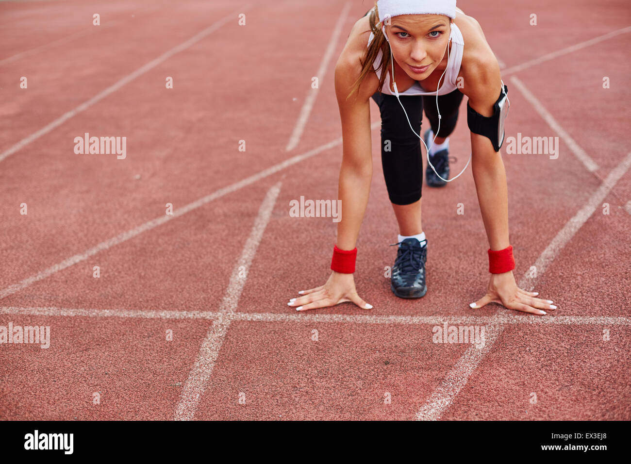 Fit girl in activewear standing at start line ready to run Stock Photo ...