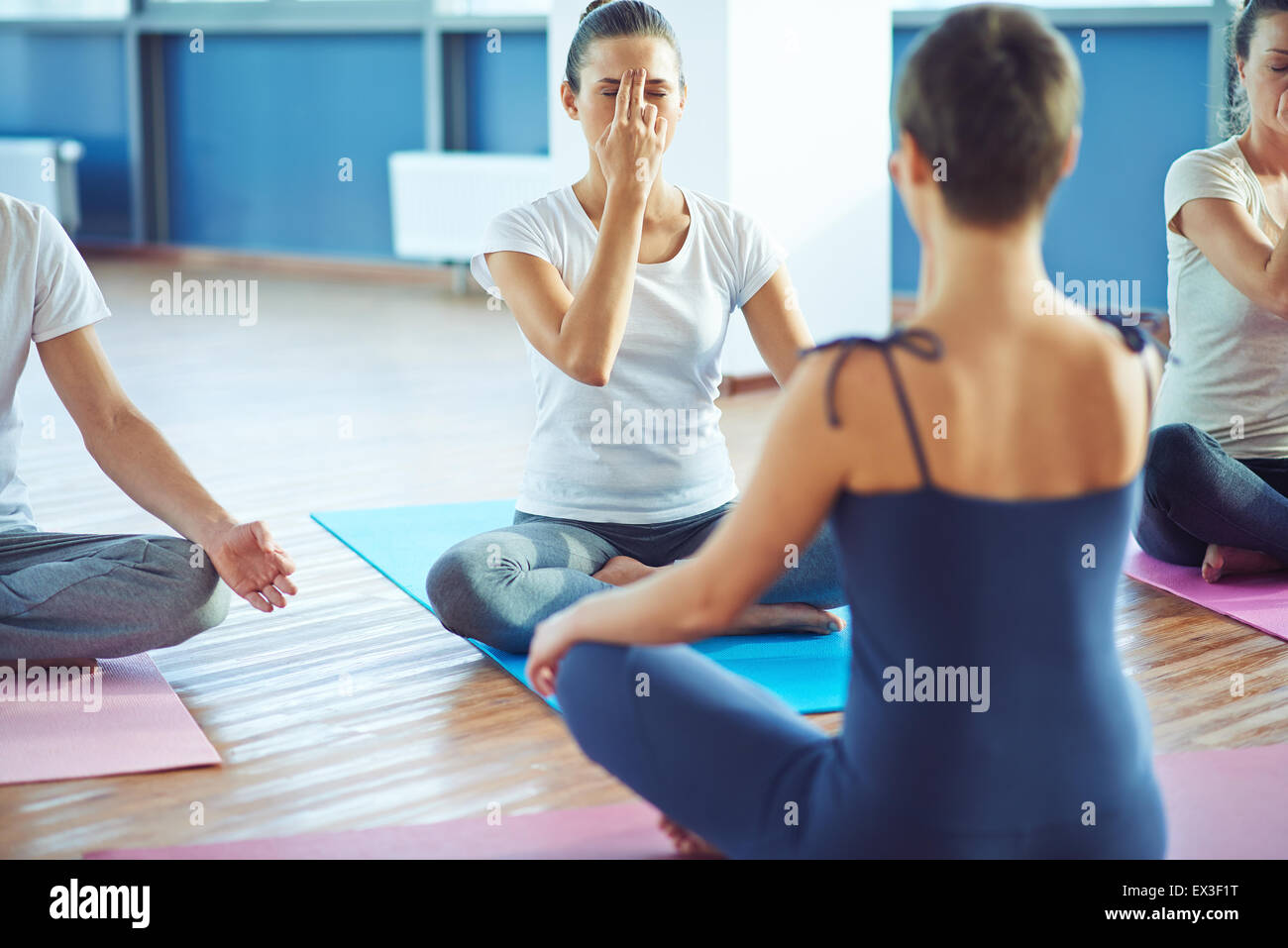 Young woman repeating yoga exercise after trainer Stock Photo - Alamy