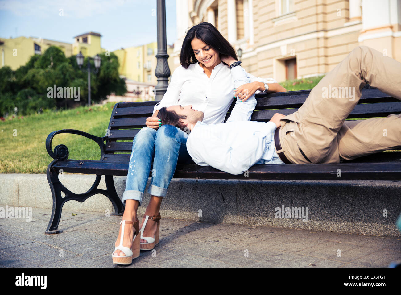 Happy young couple resting on the bench outdoors Stock Photo - Alamy