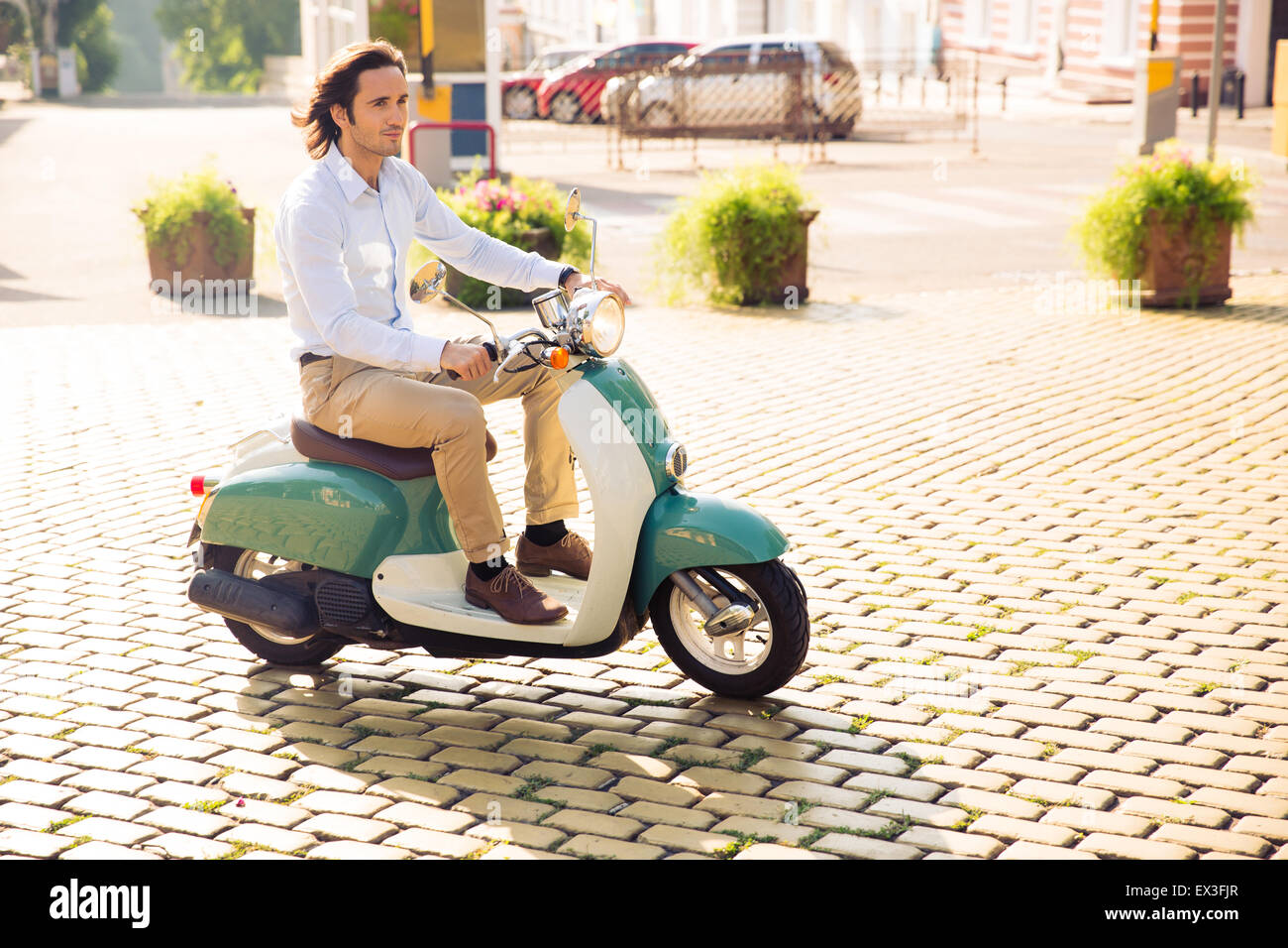 Happy young man riding on scooter in the city Stock Photo - Alamy