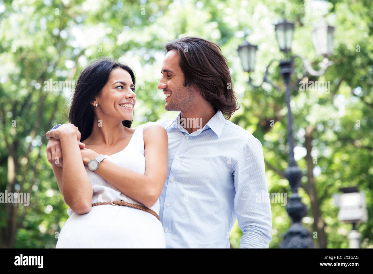 Smiling beautiful couple flirting outdoors in park Stock Photo - Alamy
