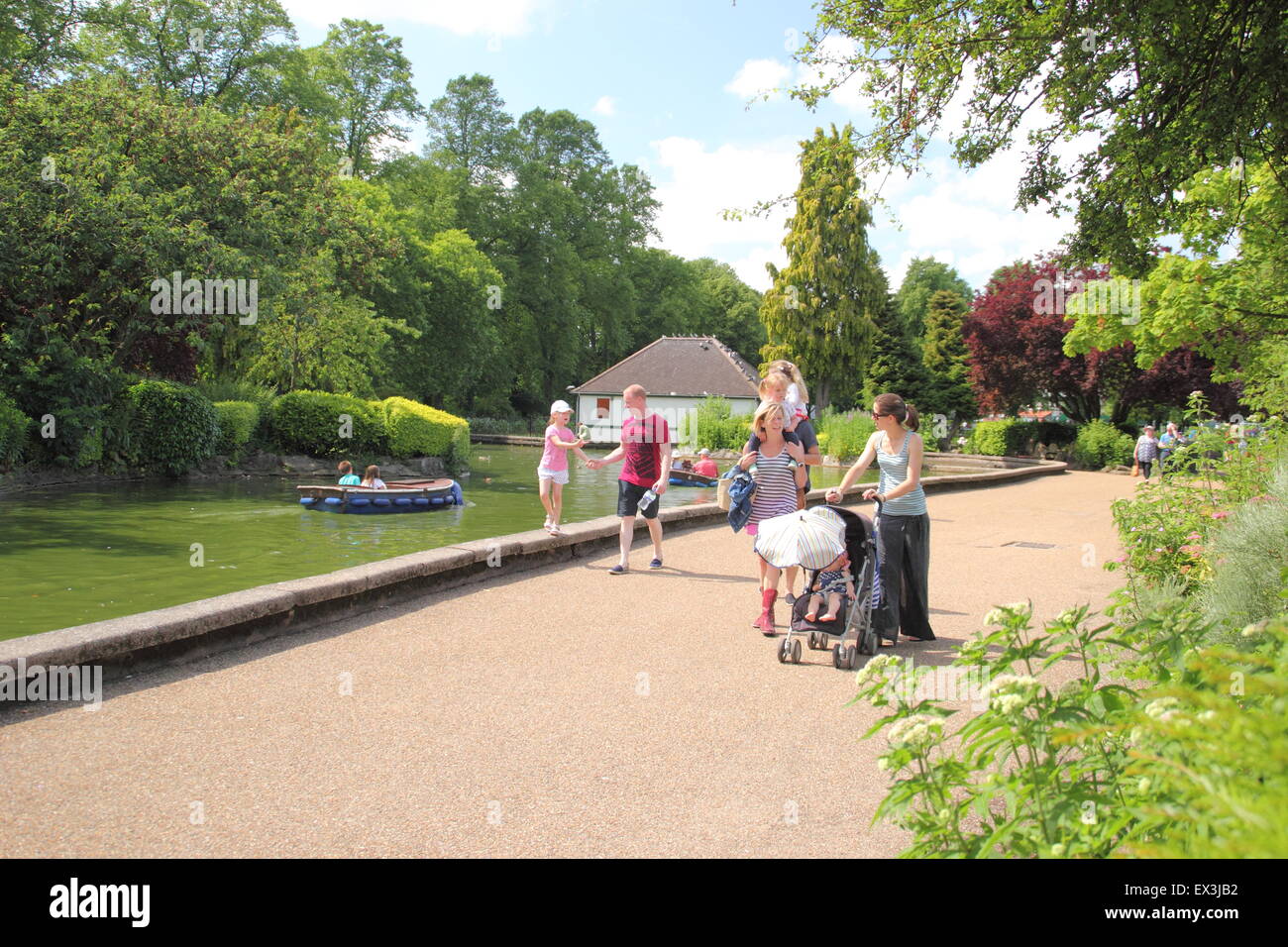 People relax on a hot summer's day by the boating lake in Hall Leys ...