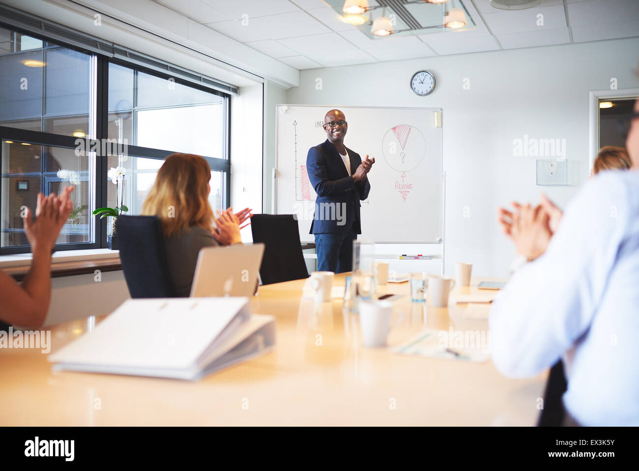 Black male executive standing at head of table in conference room ...