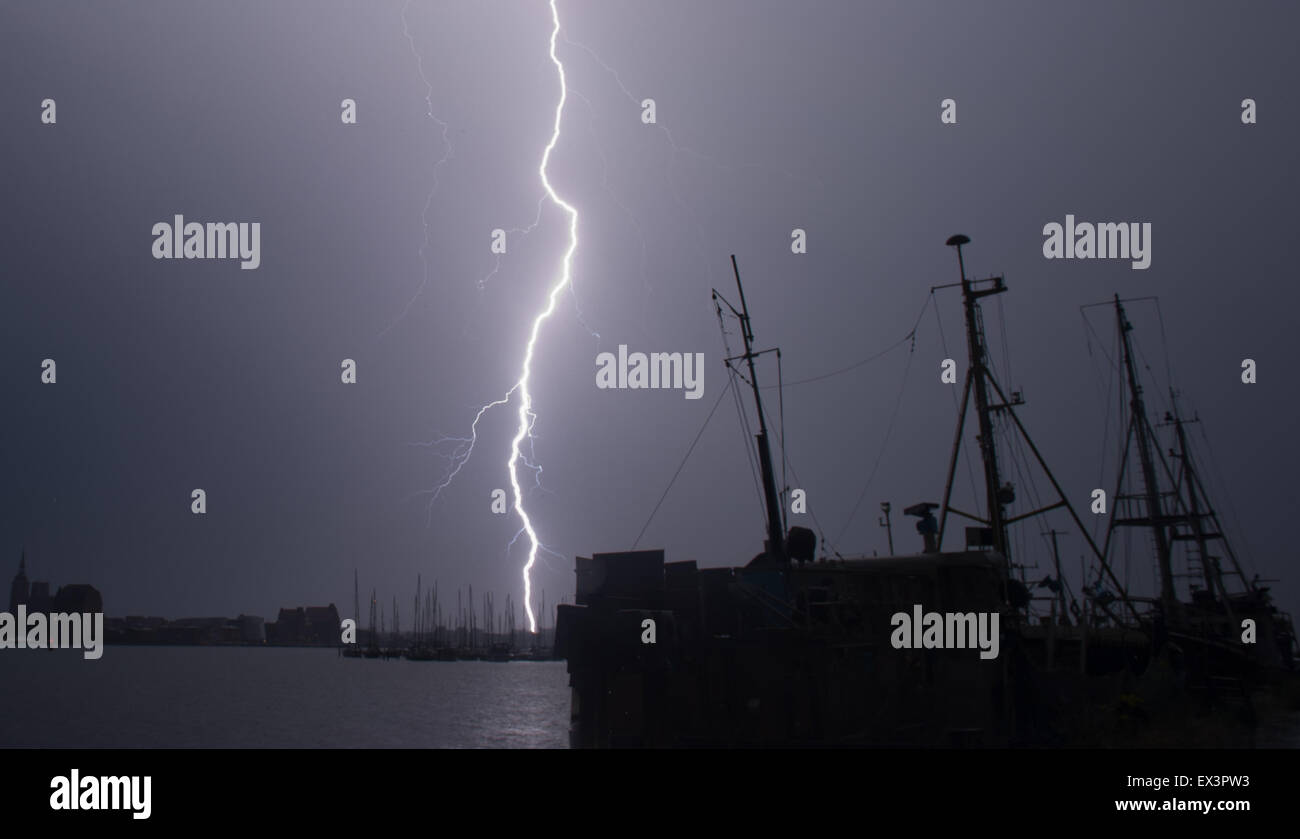 Lightening strikes through the sky during a thunderstorm over a harbour ...