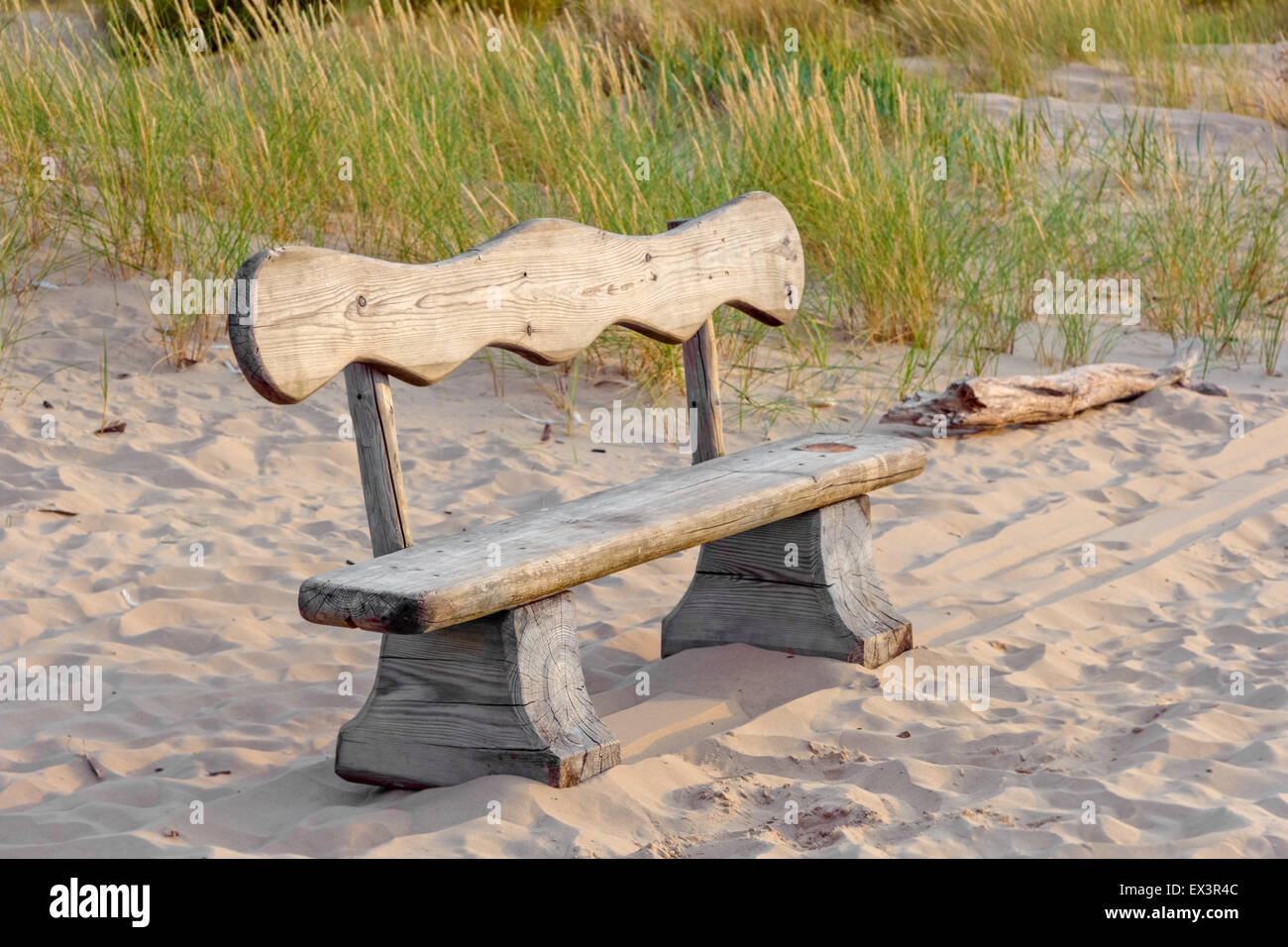 Wooden bench on summer sandy beach in sunset light Stock Photo - Alamy