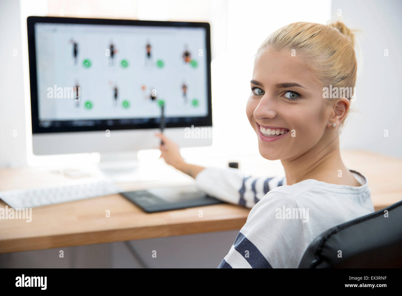 Happy female photo editor working on computer in a office Stock Photo ...