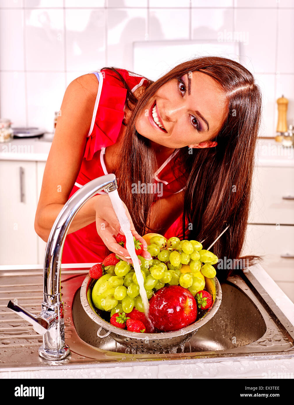 Woman washing fruit at kitchen Stock Photo - Alamy