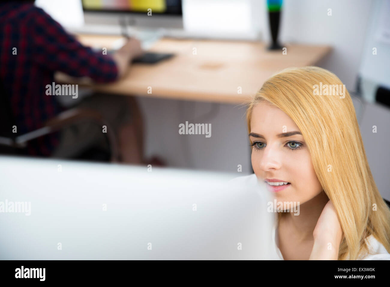 Happy young girl working on computer in office Stock Photo - Alamy
