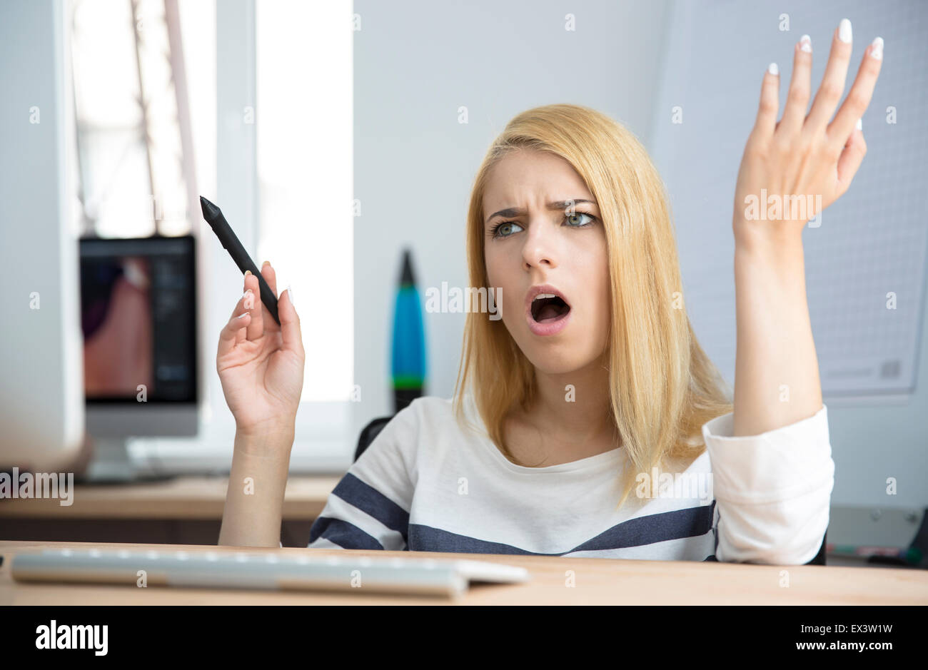 Angry young woman working on computer in office Stock Photo - Alamy