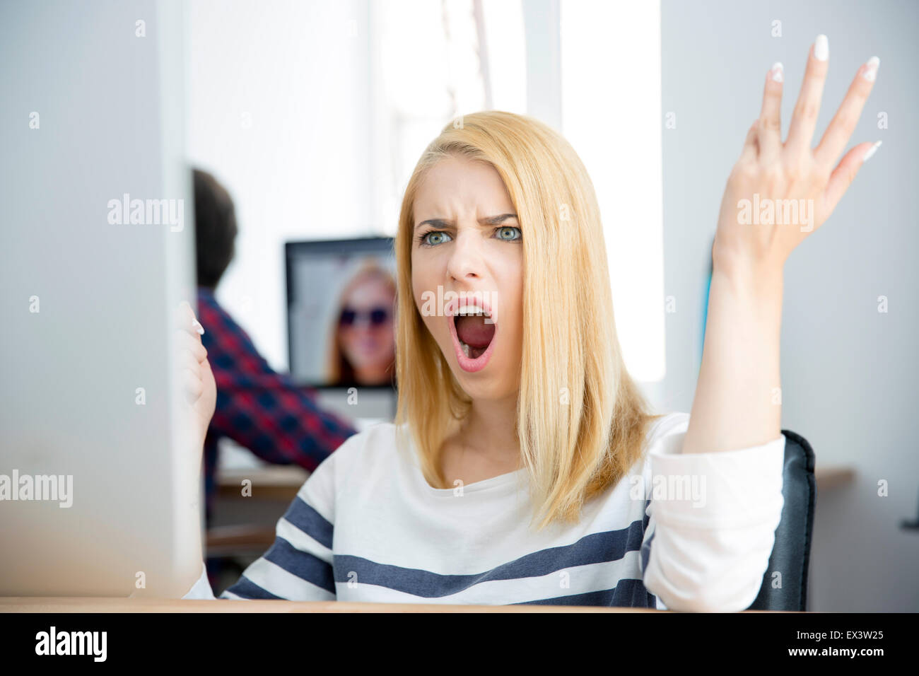Shocked young woman working on computer in office Stock Photo - Alamy